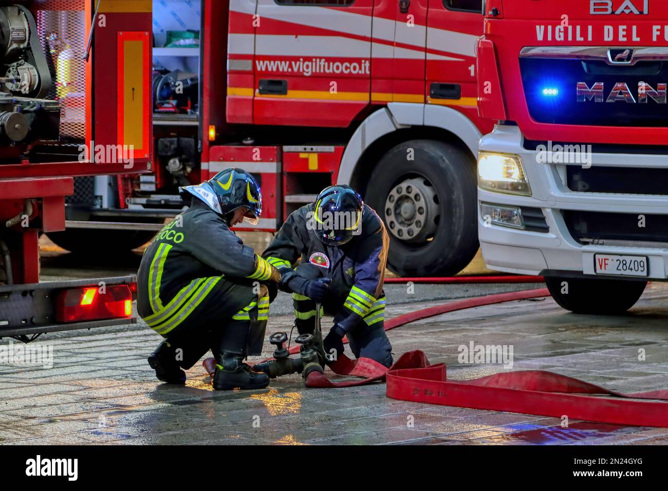 Italian firefighters at work during a fire in an attic of a building in ...