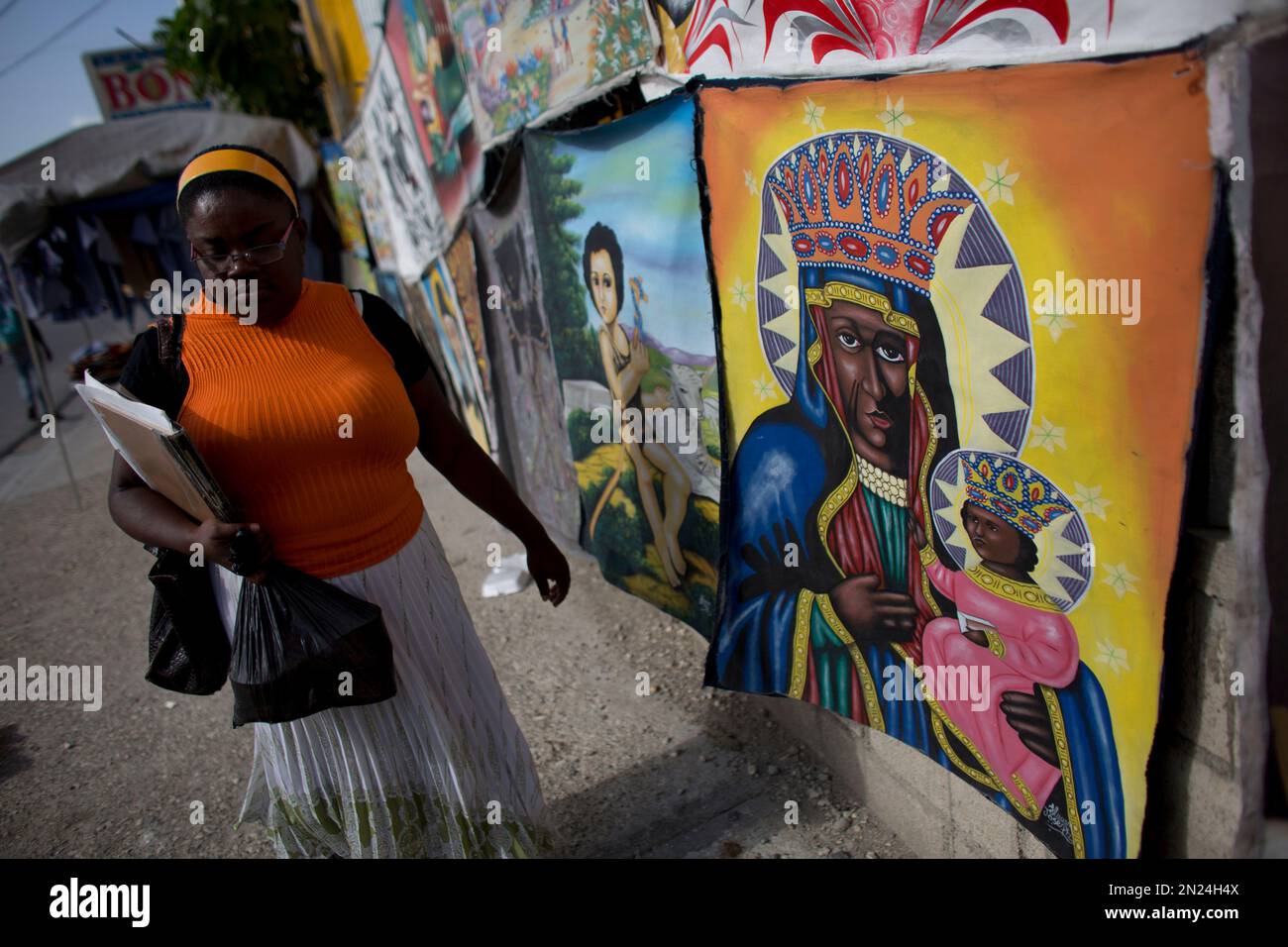 A woman walks past a painting depicting the voodoo spirit Erzulie ...