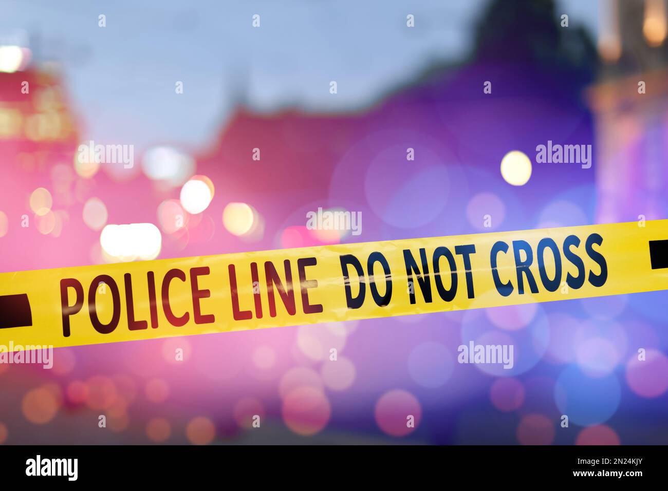 Yellow law enforcement tape isolating crime scene. Blurred view of city ...