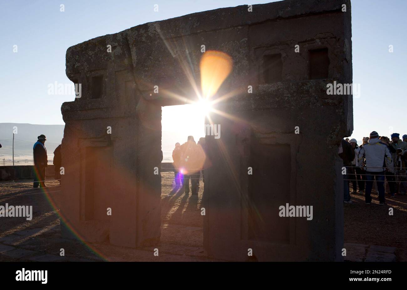 People observe the first rays of sun as they appear through the "Door ...