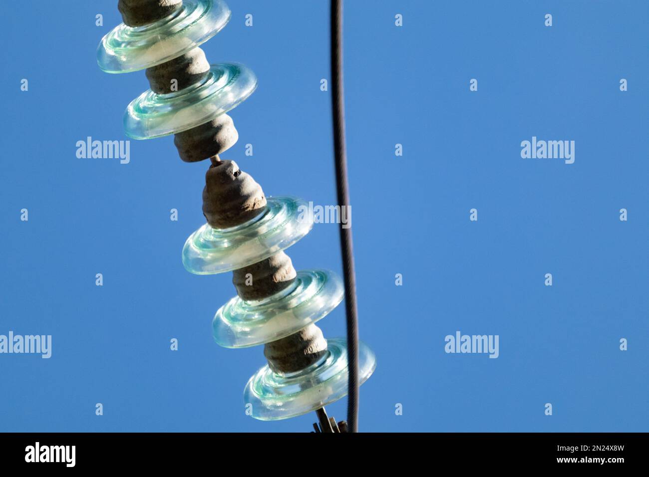 Glass insulators electric wire close-up. High voltage line details with ...