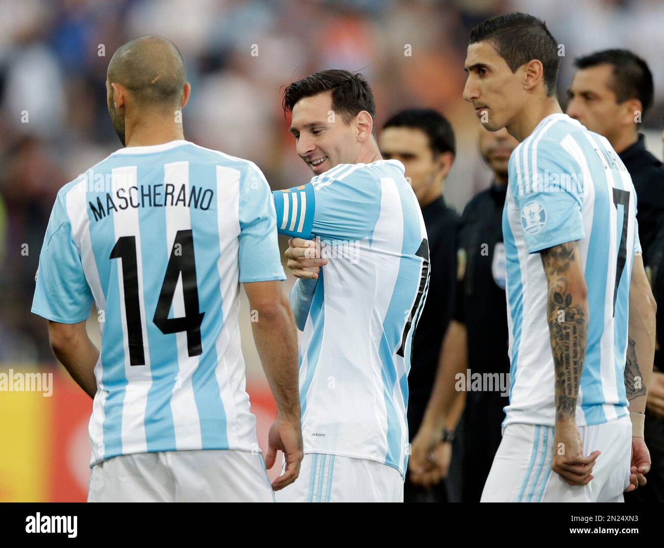 Argentina's Lionel Messi, center, adjusts his captain arm band, flanked ...