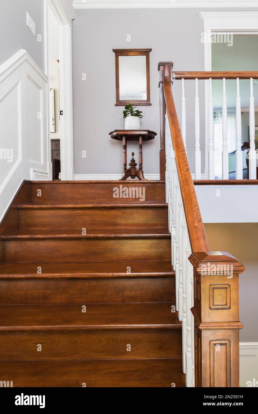 Cherry wood stairs and handrail with white spindles leading to upper ...