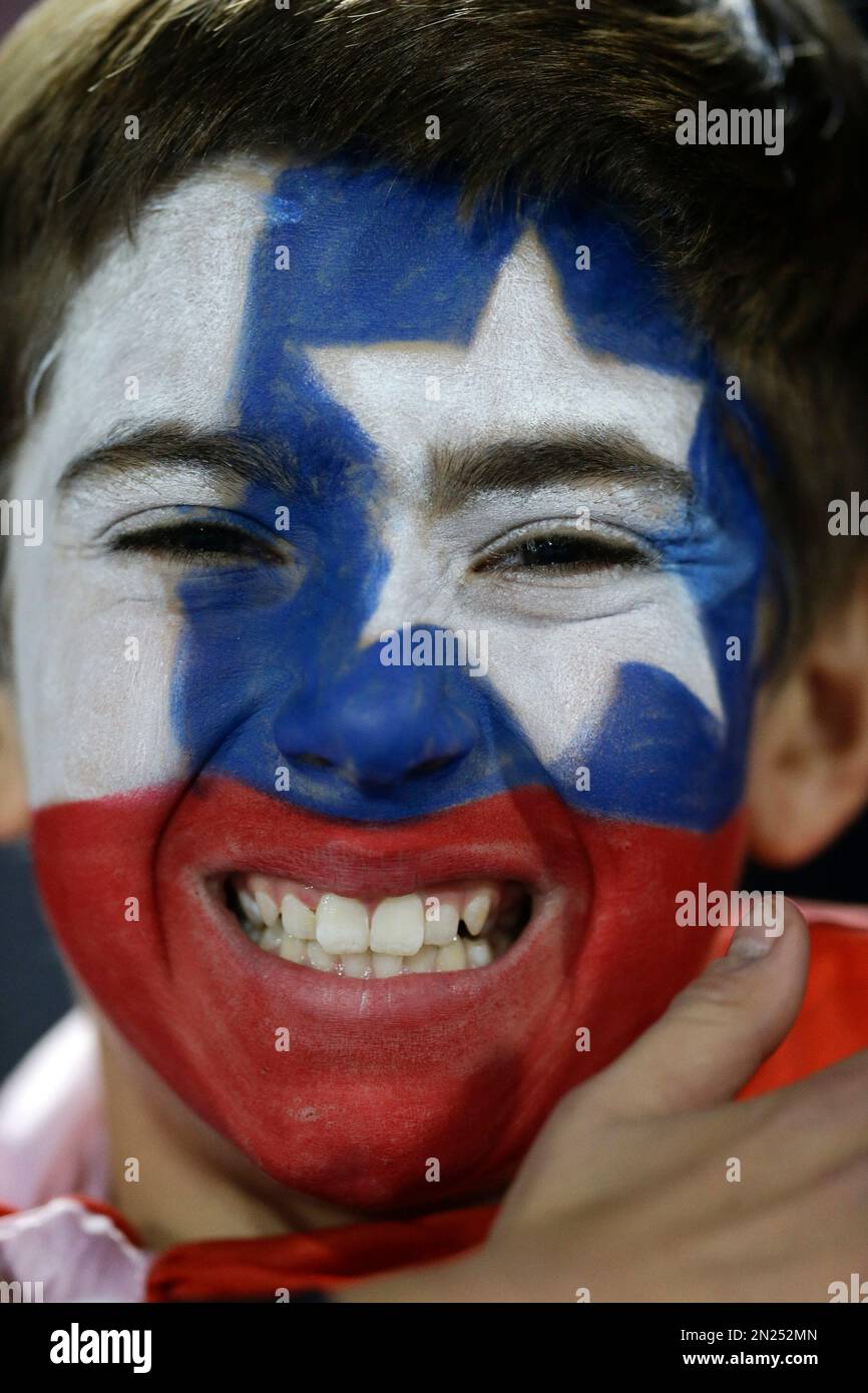 A Chile's fan with his face painted with the colors of the national ...