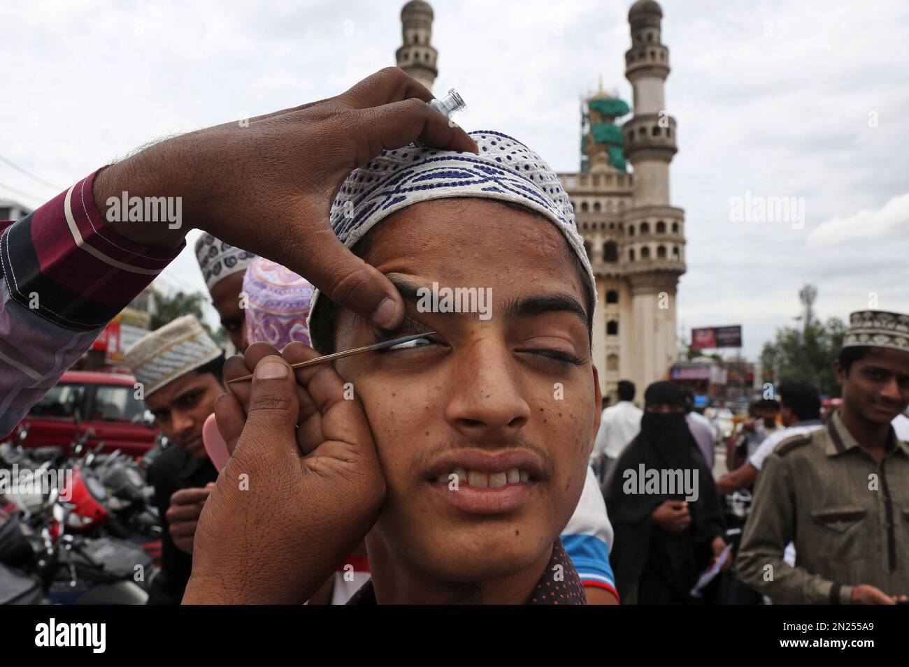 An Indian Muslim gets his eyes lined with a black ointment called Surma ...