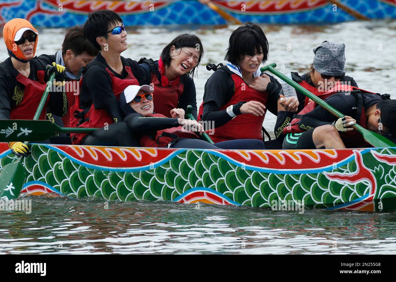 Members of an exhausted rowing team react after a traditional Chinese ...