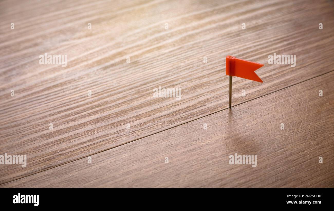 Red color flag pin isolated on a wooden background with copy space ...