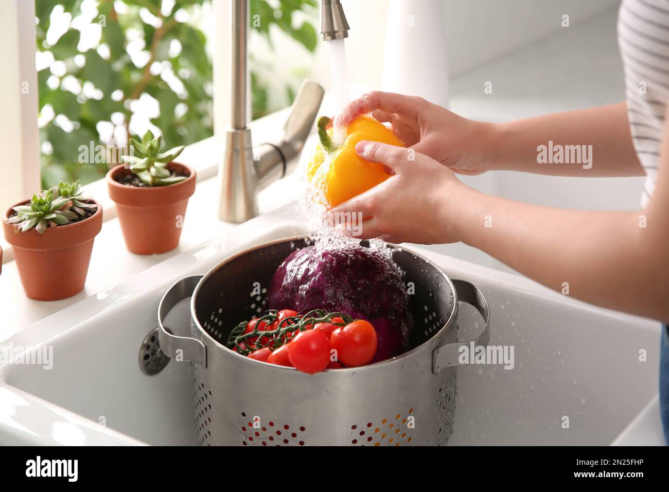 Woman washing fresh bell pepper in kitchen sink, closeup Stock Photo - Alamy