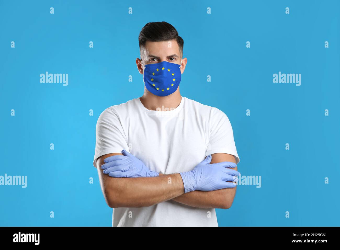 Man wearing medical mask with European Union flag on light blue ...