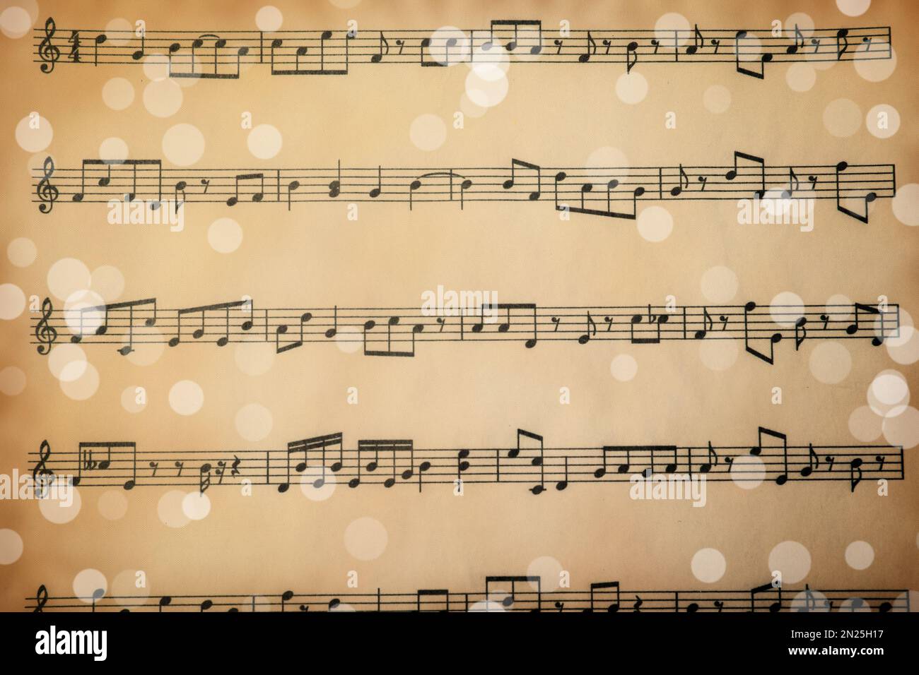 Top view of old sheet with Christmas music notes as background, bokeh ...