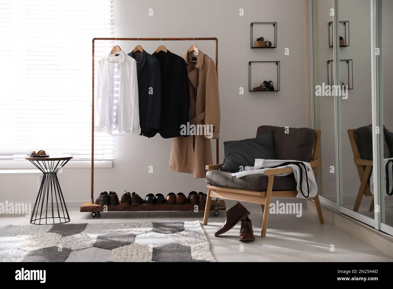 Dressing room interior with clothing rack and armchair Stock Photo - Alamy