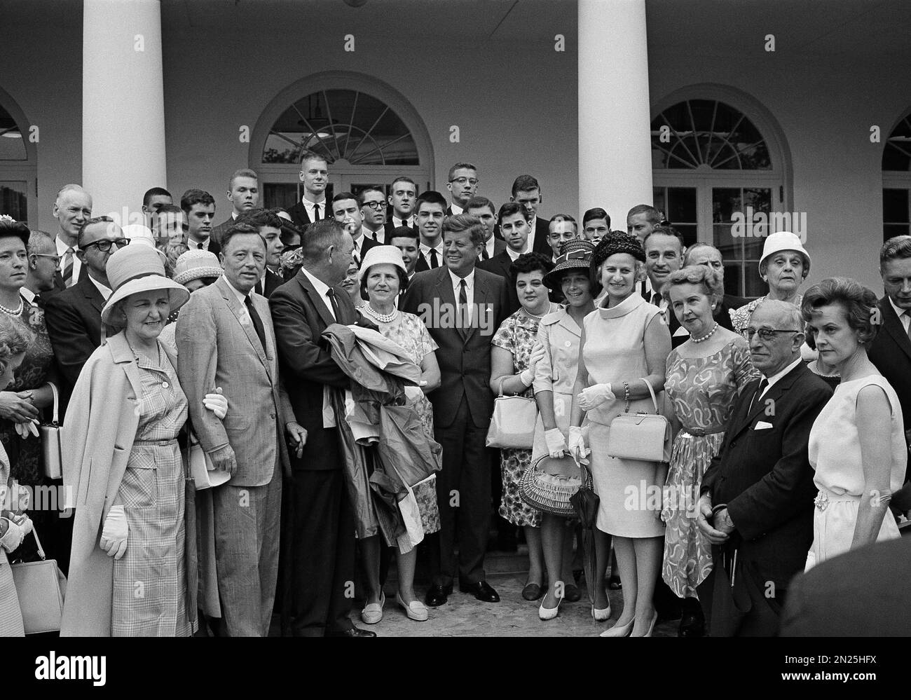 President John F. Kennedy poses with graduates (background) of the ...