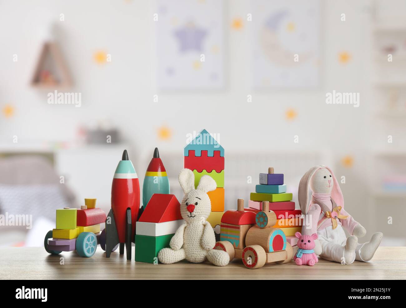 Set of different cute toys on wooden table in children's room Stock ...