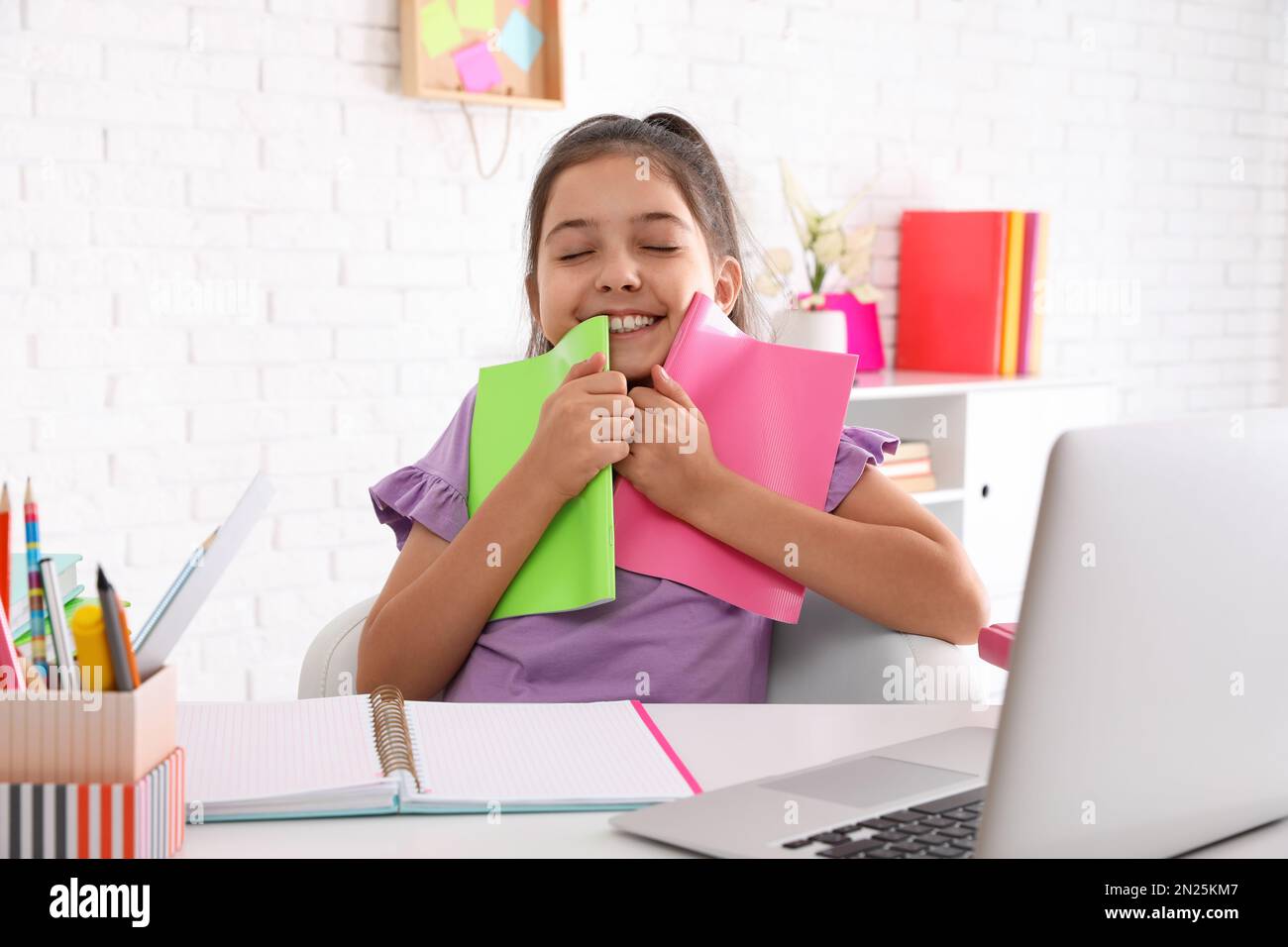 Happy girl sitting table writing hi-res stock photography and images ...