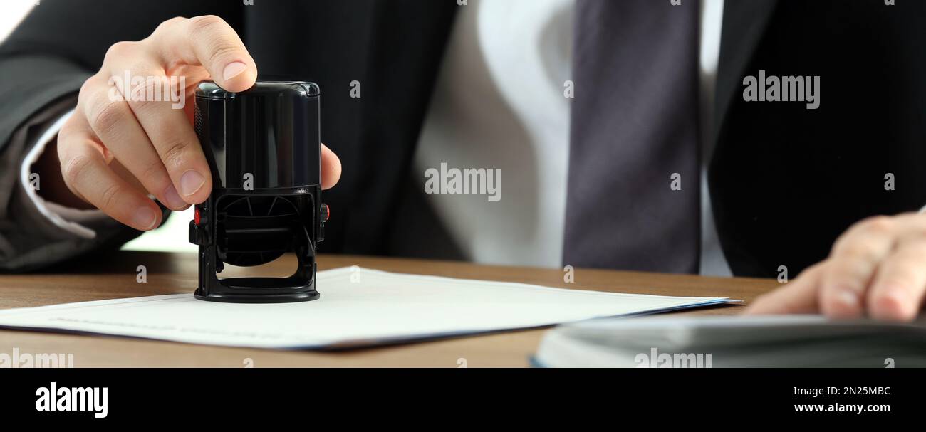 Notary stamping document at table, closeup. Banner design Stock Photo ...