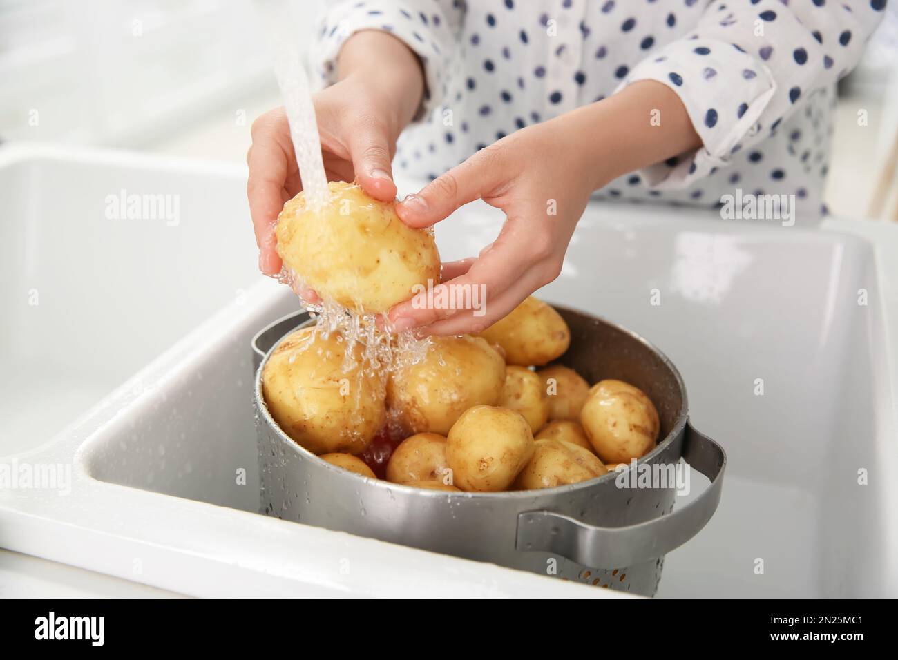Woman washing fresh potatoes in kitchen sink, closeup Stock Photo - Alamy