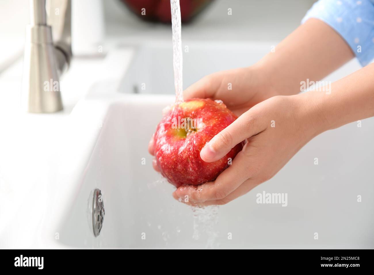 Woman washing fresh red apple in kitchen sink, closeup Stock Photo - Alamy