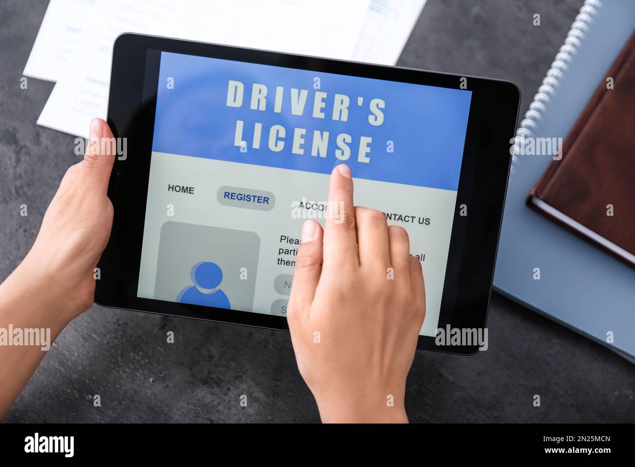Person using tablet to fill driver's license application form at grey table, closeup Stock Photo ...