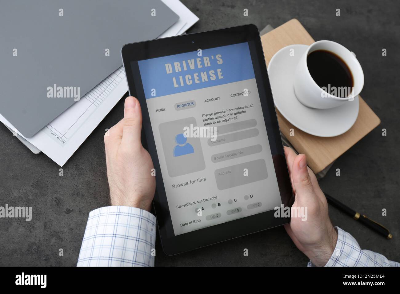 Man holding tablet with driver's license application form at grey table, closeup Stock Photo - Alamy