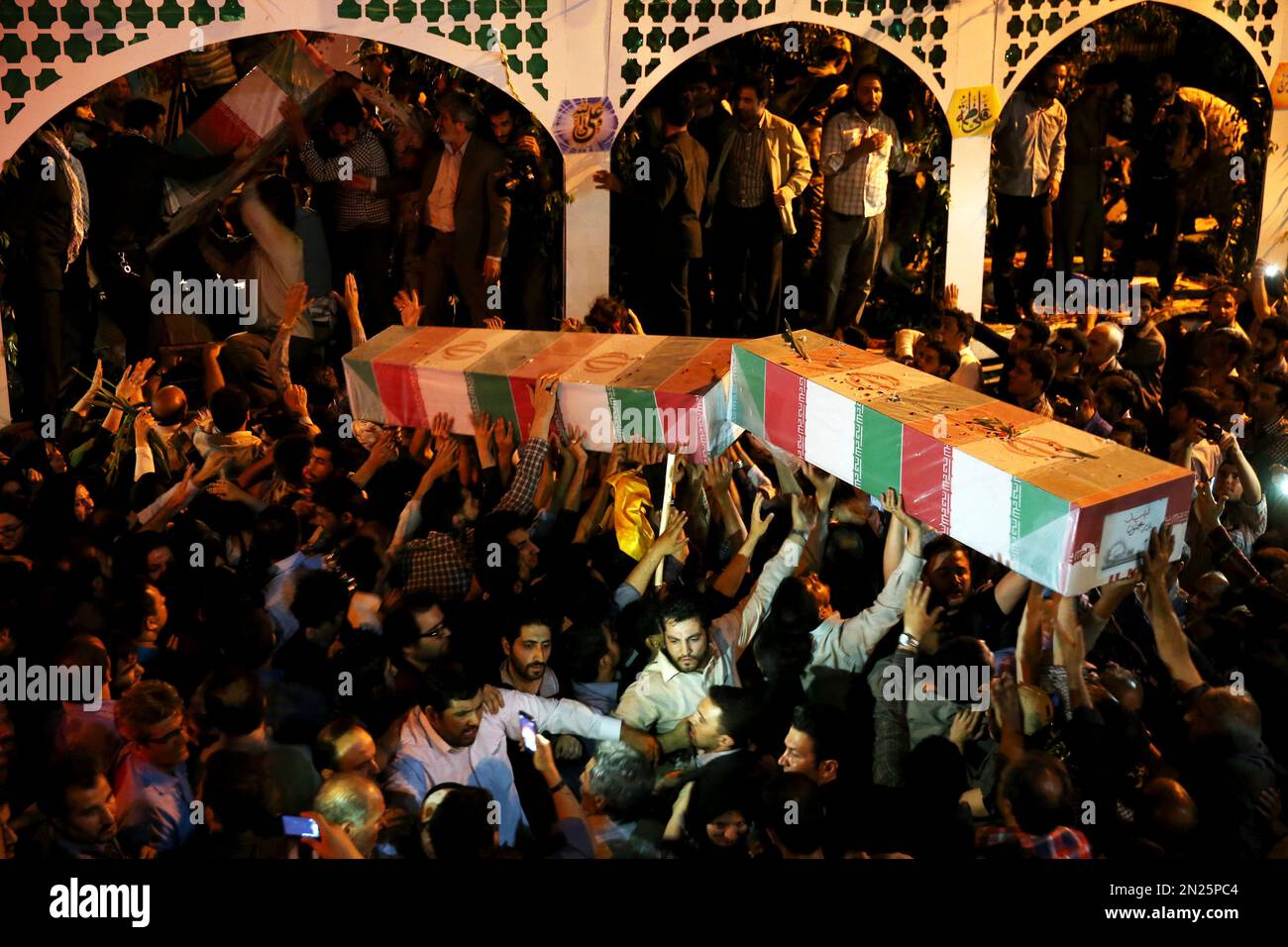Iranian mourners carry flag-draped coffins of soldiers killed during ...