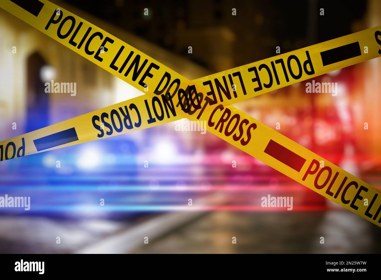 Yellow law enforcement tape isolating crime scene. Blurred view of city ...