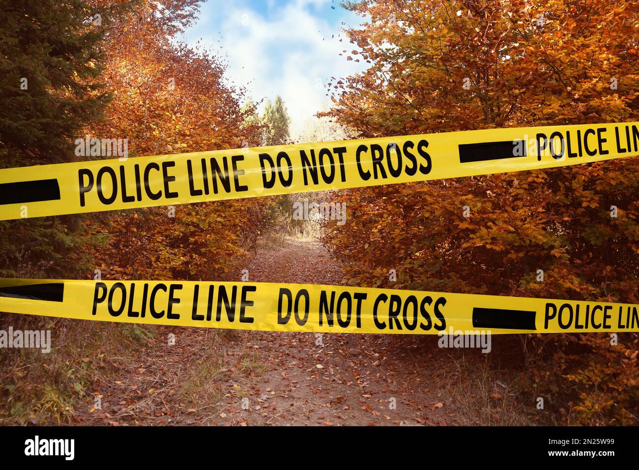 Yellow police tape isolating crime scene. Restricted area of autumn ...