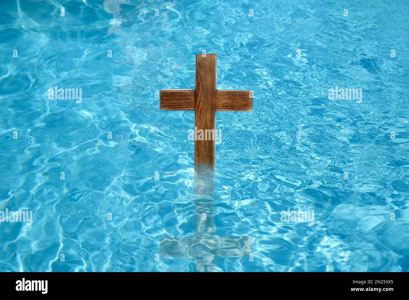 Wooden cross in water for religious ritual known as baptism Stock Photo ...