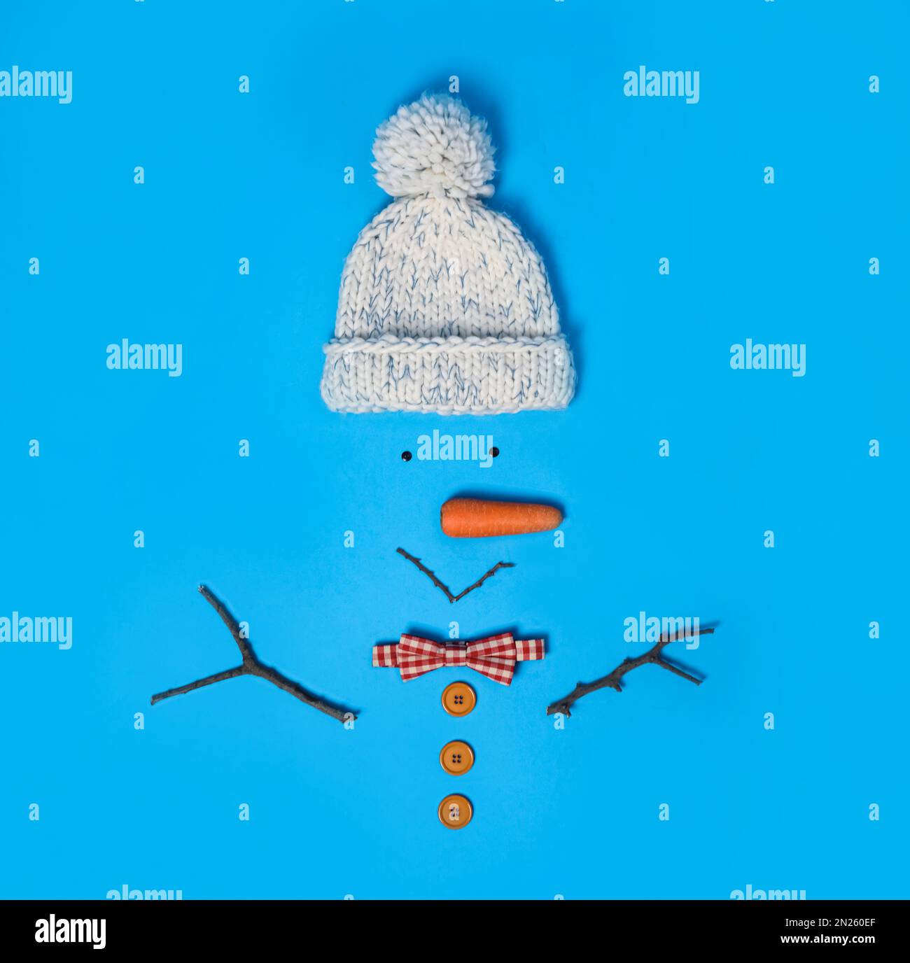 Creative snowman shape made of different items on light blue background ...