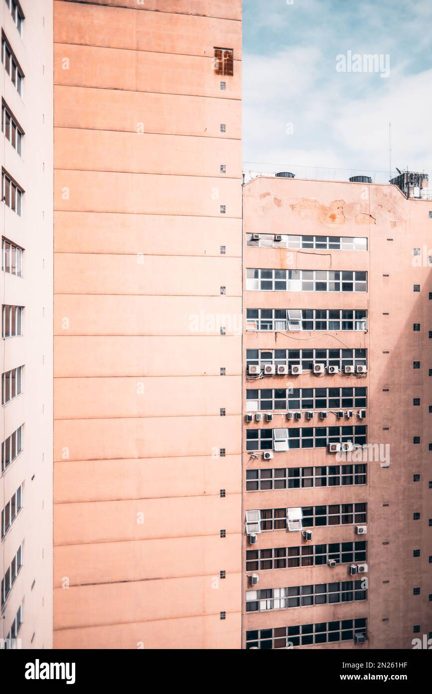 A vertical capture of an inner corner of two salmon-colored buildings ...