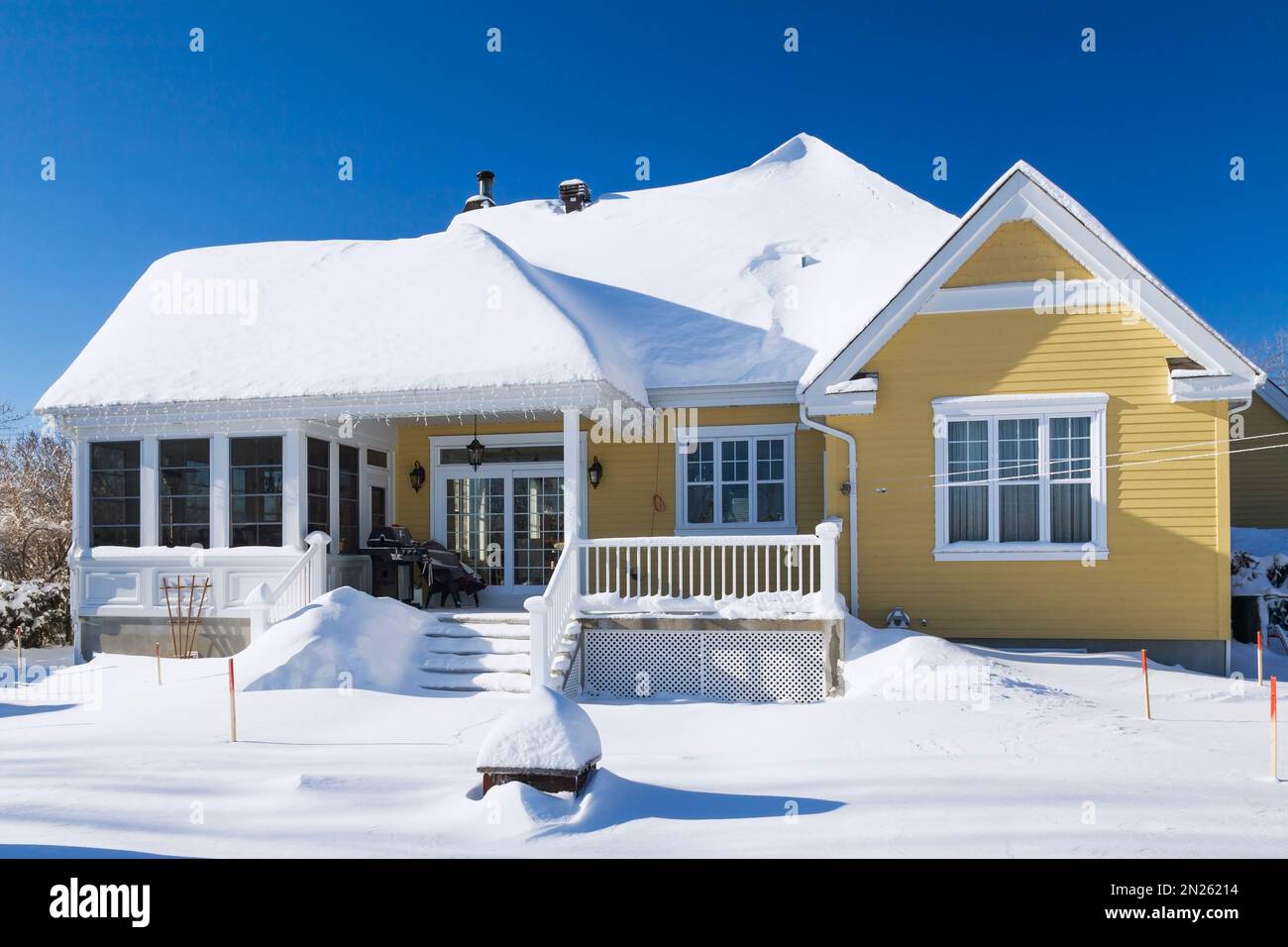 Rear of yellow with white trim cottage style house in winter Stock ...