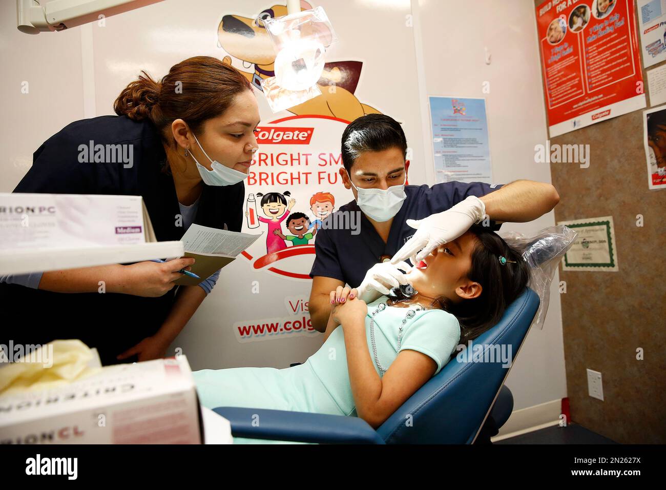UT Health Dental School student volunteers provide a free dental screening on a child as part of ...