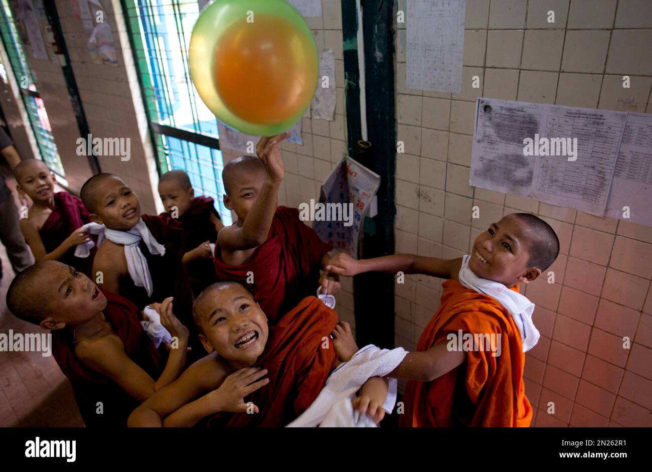 Novice Buddhist monks play with a balloon at a monastic school in ...