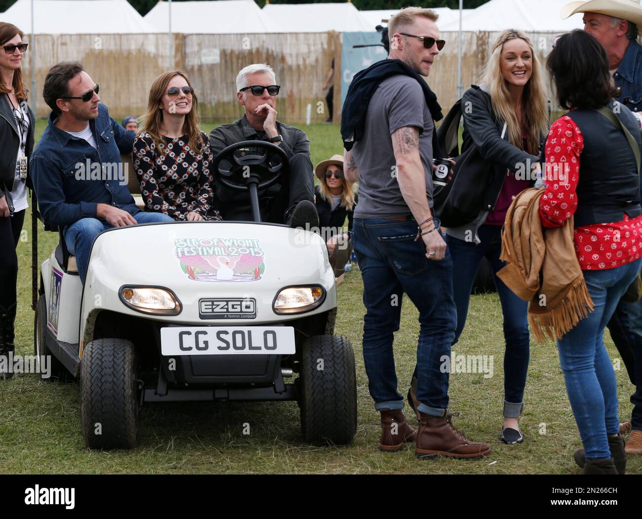 Jack Horner and Geri Halliwell sit on a golf cart with John Giddings ...