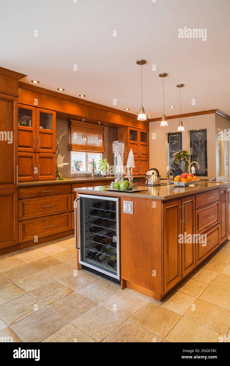 Cherry wood cabinets and island with quartz countertops in kitchen ...