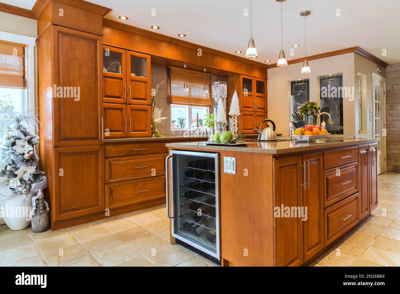Cherry wood cabinets and island with quartz countertops in kitchen ...