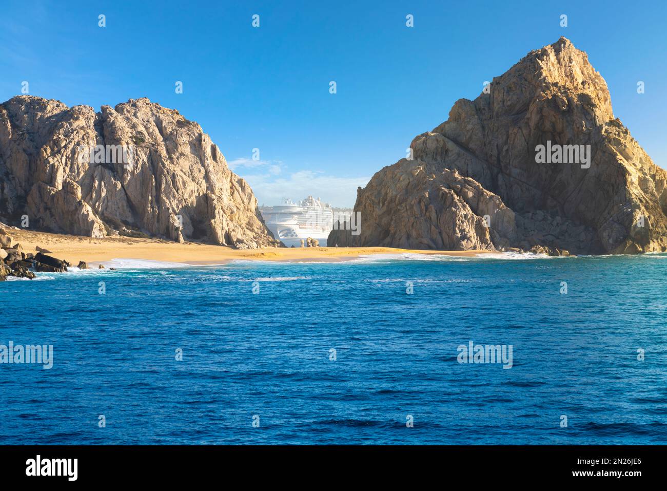 A Cruise Ship Can Be Seen Between Two Rocks Above Lovers Beach At The El Arco Coastal Formation