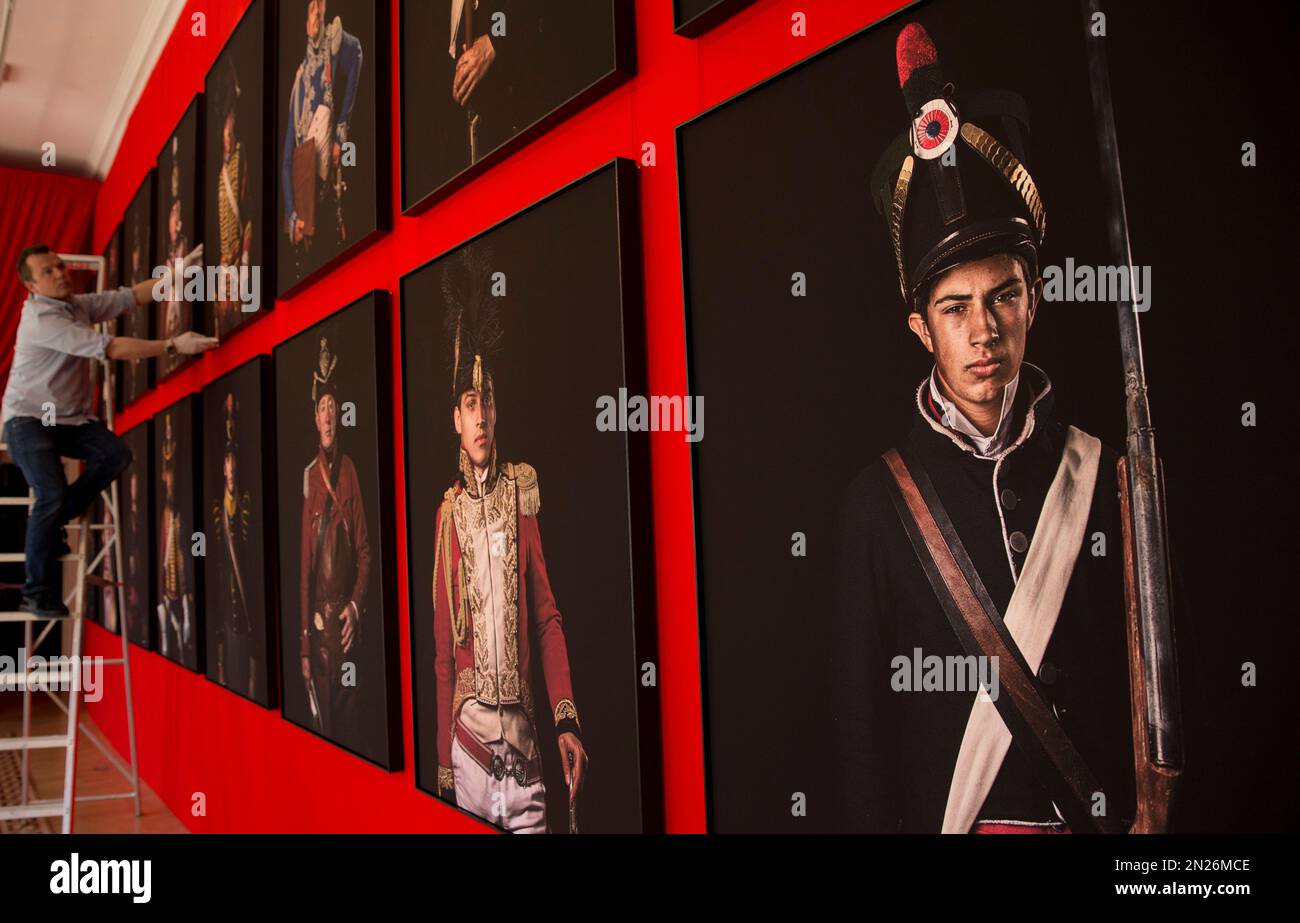 British photographer Sam Faulkner, poses with photographic portraits of ...