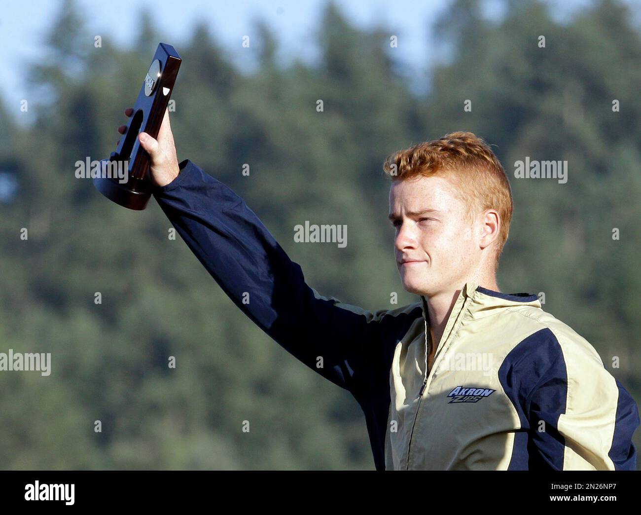 Akron's Shawn Barber holds up his trophy after winning the pole vault ...