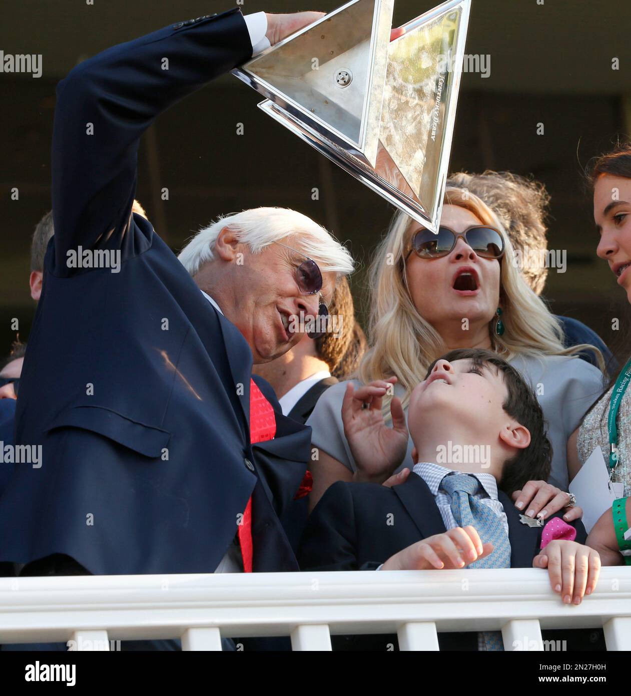 Trainer Bob Baffert holds up the Triple Crown Trophy with his son, Bode ...
