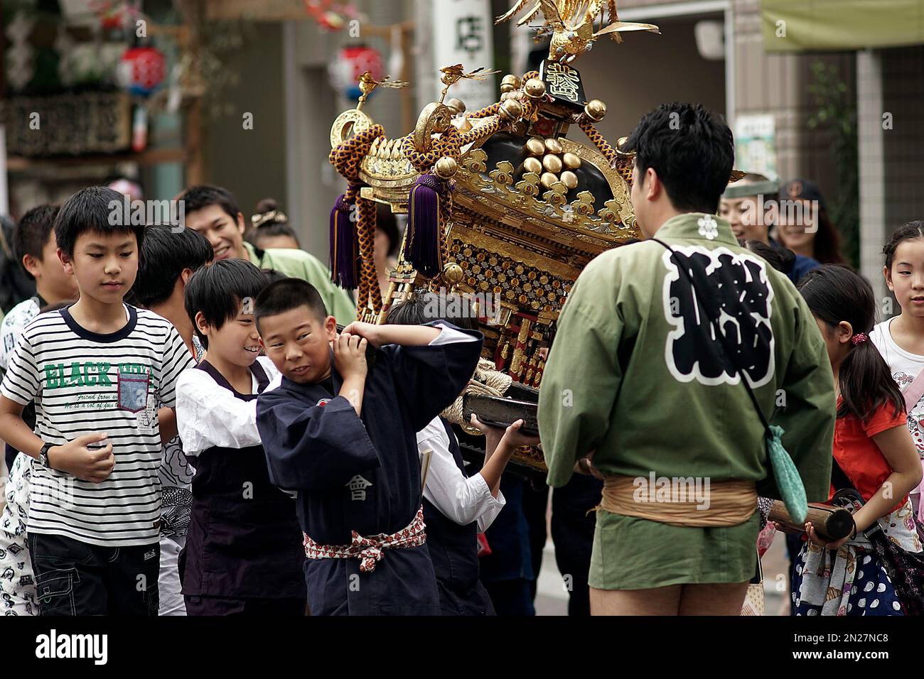 Children from a local neighborhood carry a portable shrine to celebrate ...