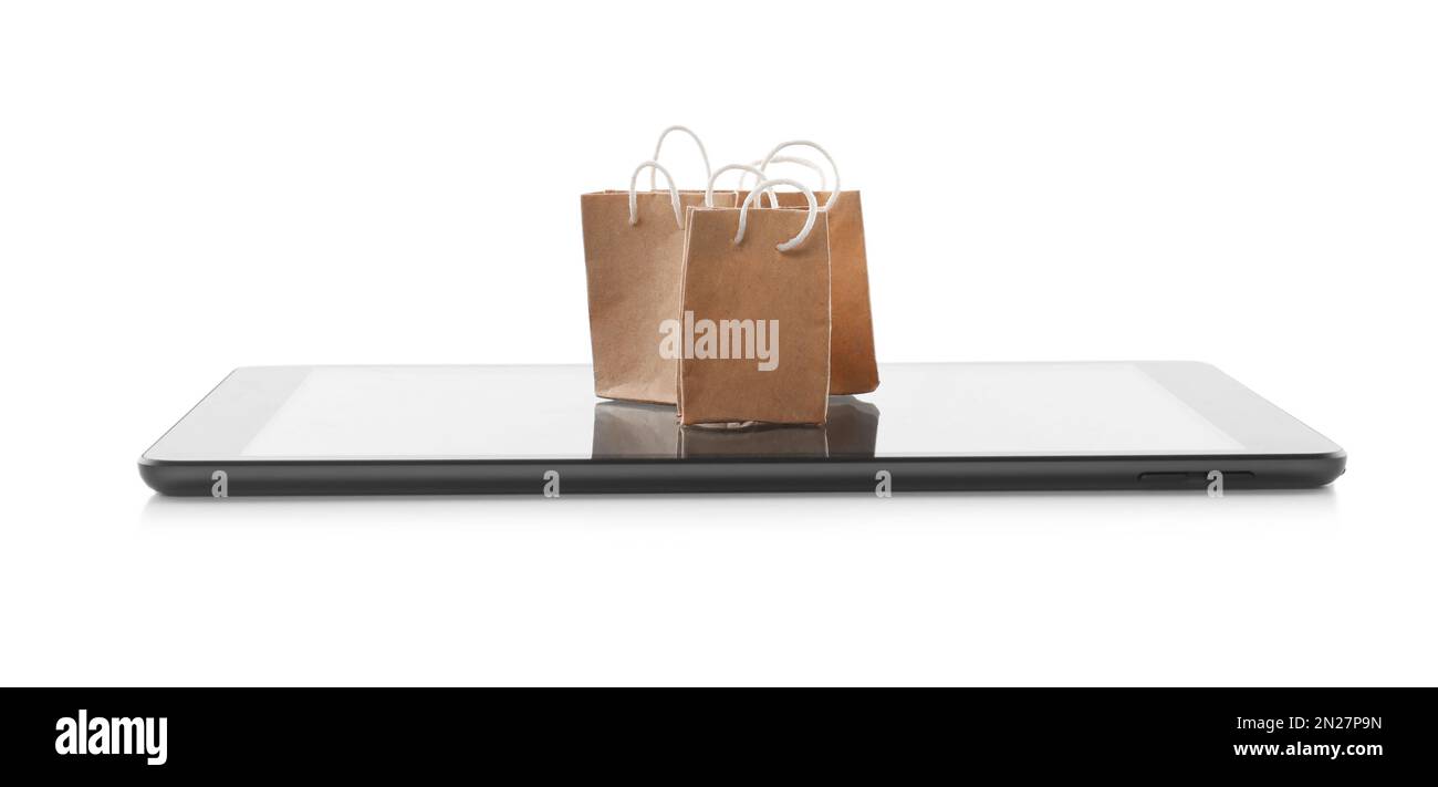 Internet shopping. Small paper bags and modern tablet on white ...