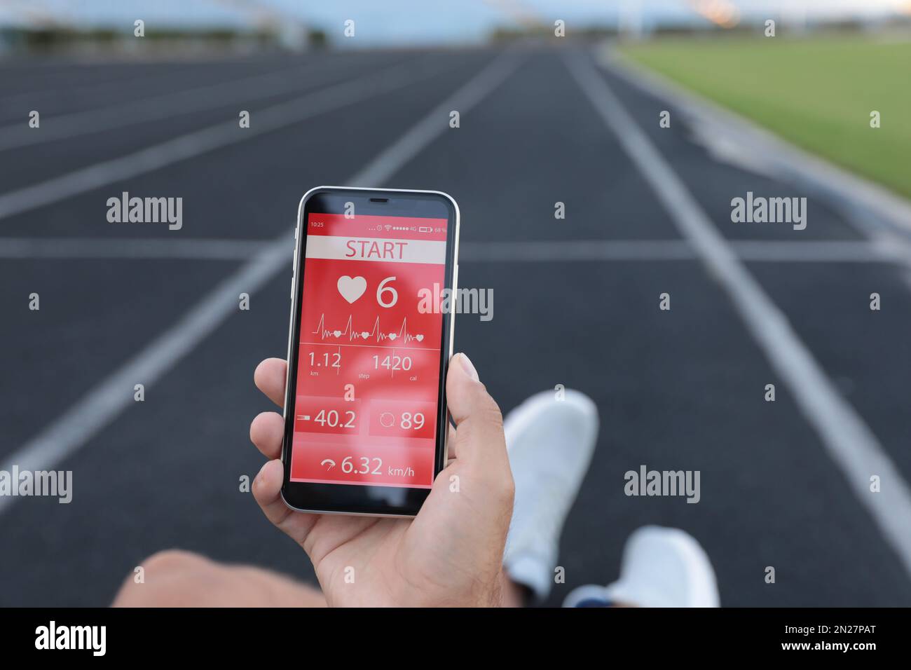Man using fitness app on smartphone at stadium, closeup Stock Photo - Alamy