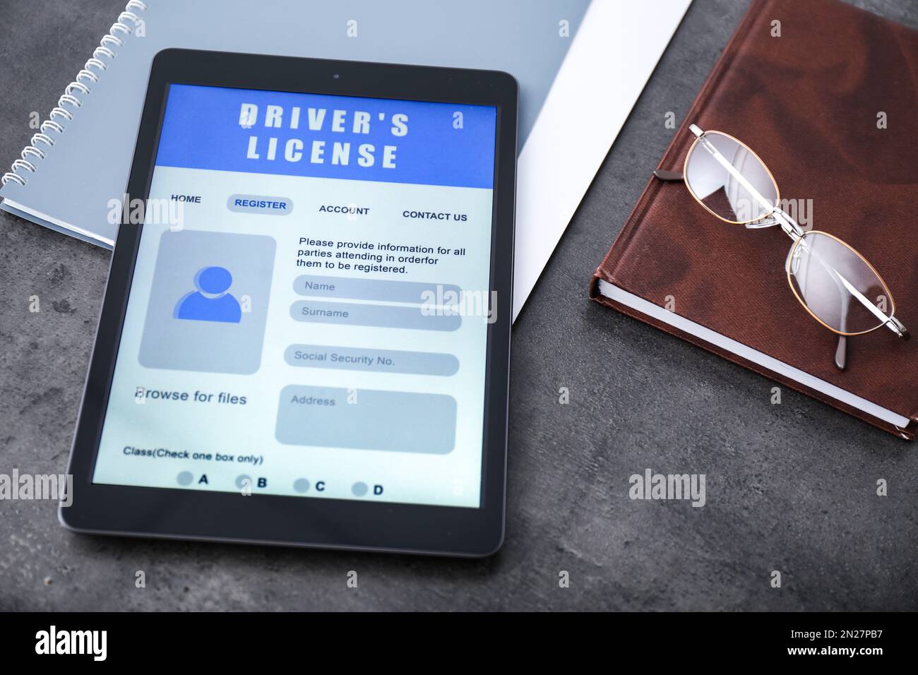 Tablet with driver's license application form, glasses and stationery ...