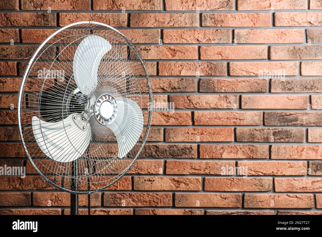 Electric fan near brick wall, space for text. Summer heat Stock Photo ...