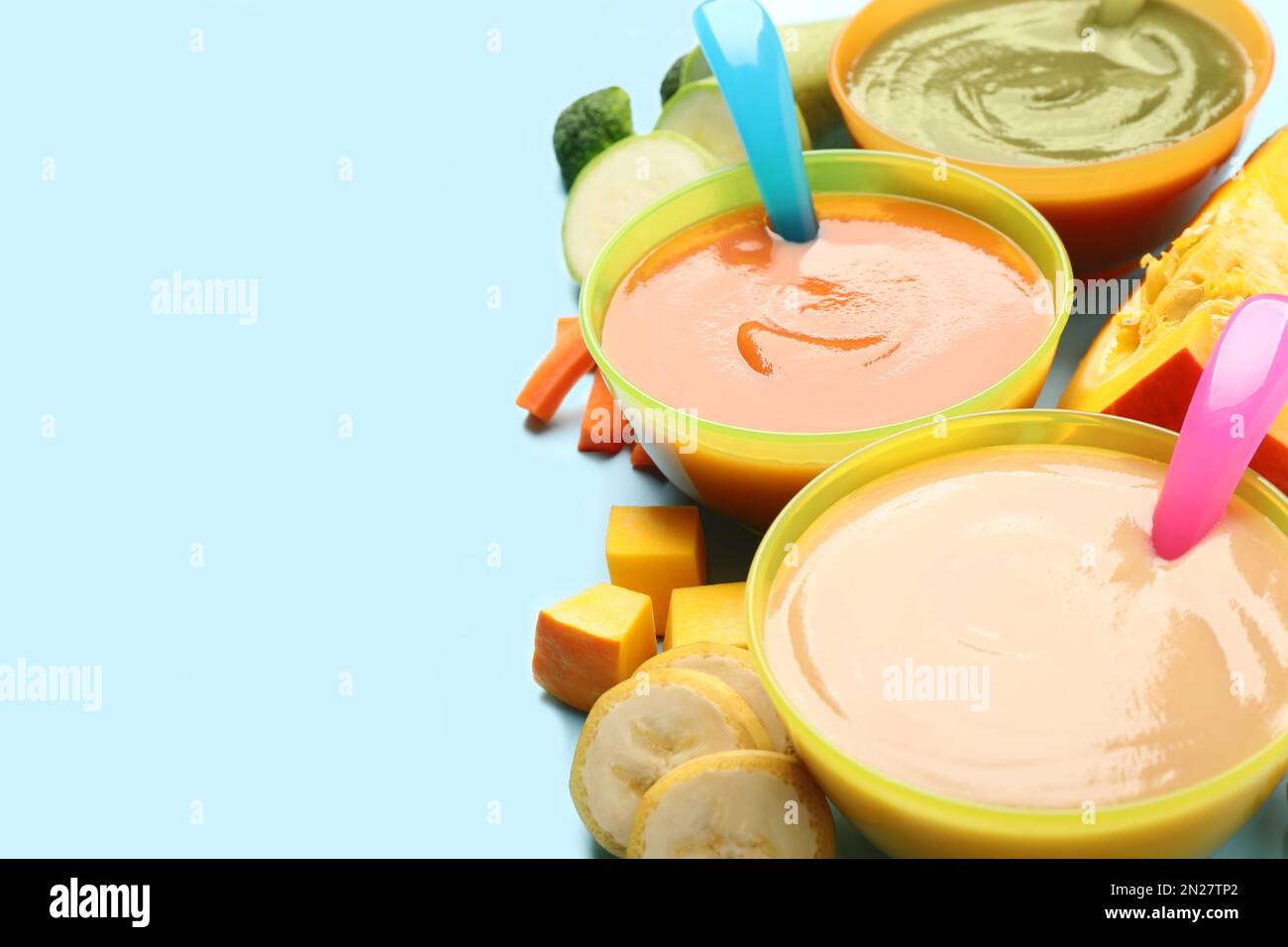 Healthy baby food and fresh ingredients on light blue background ...