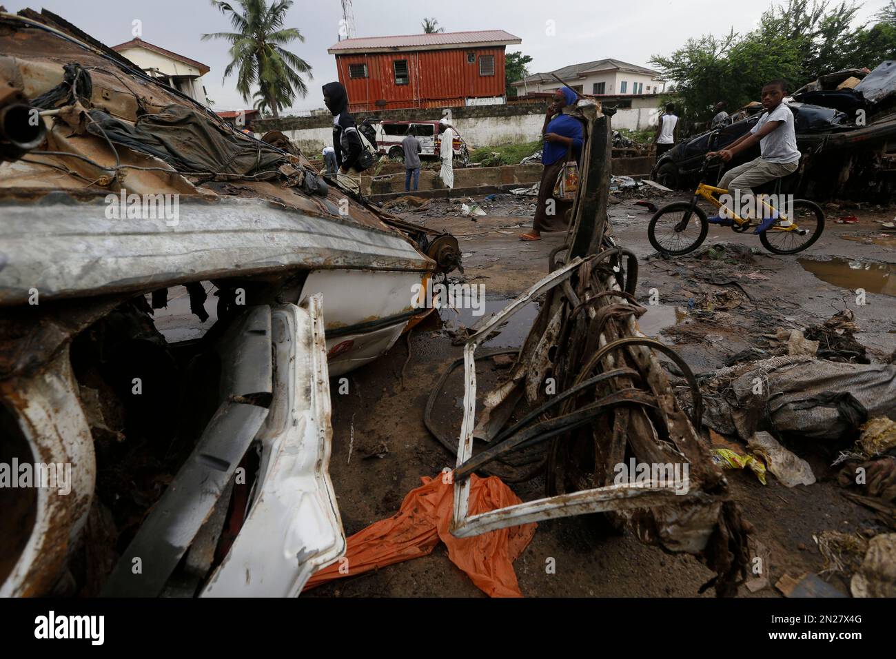 People gather around cars destroyed by flash floods in Accra, Ghana ...