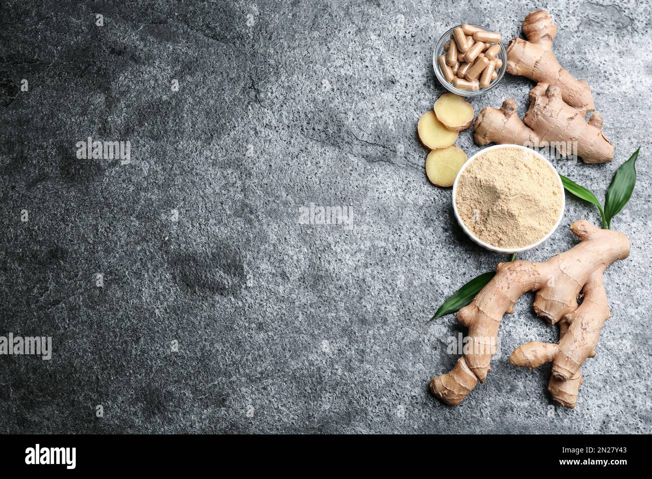Dry, fresh and capsuled ginger on grey table, flat lay. Space for text ...