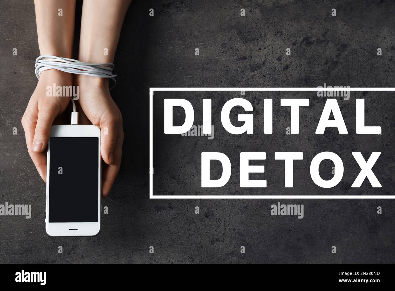 Digital detox concept. Woman holding mobile phone in hands tied with ...