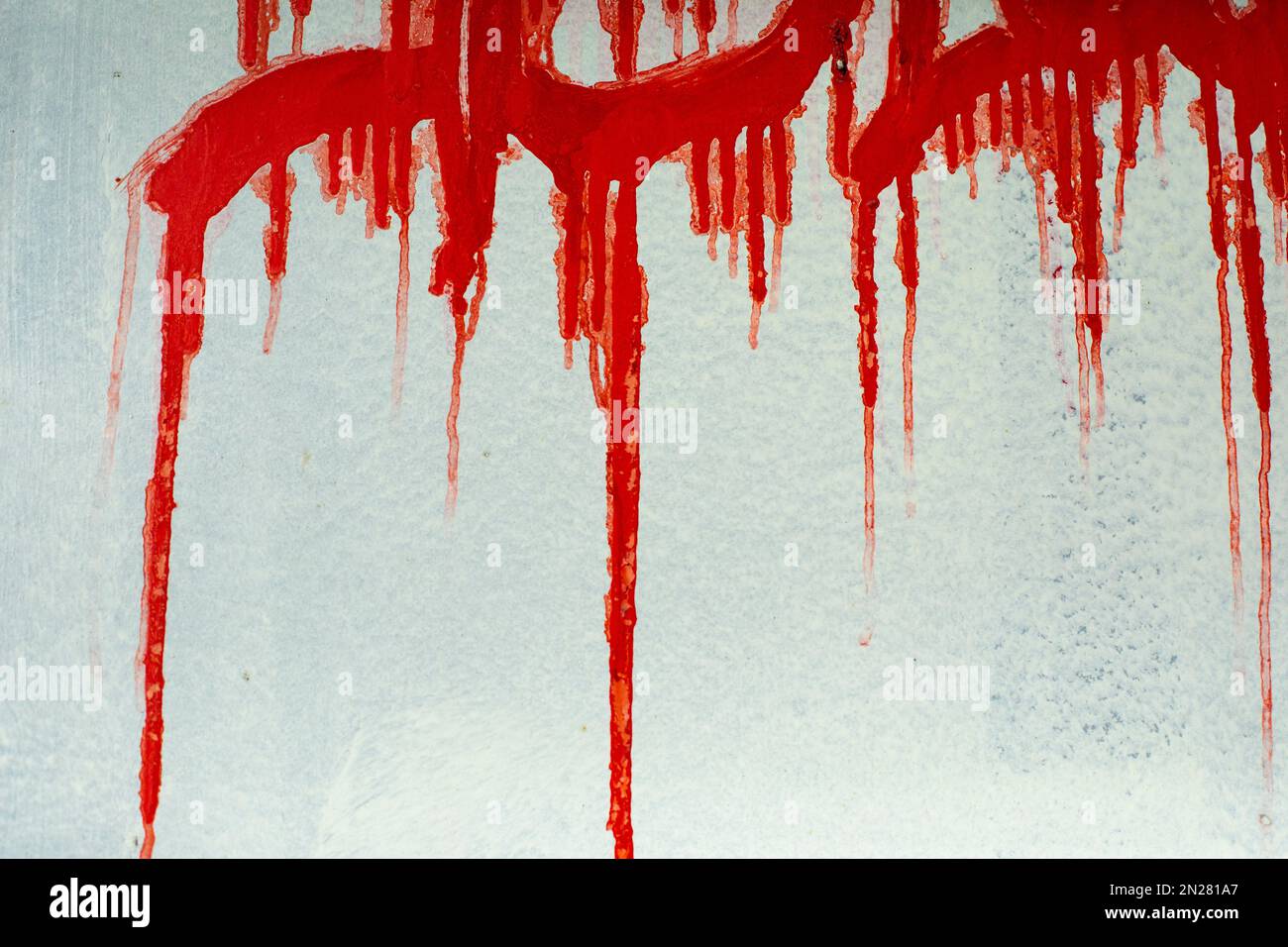 Red blood on wall. Red paint drips down grey wall. Smudges from ...