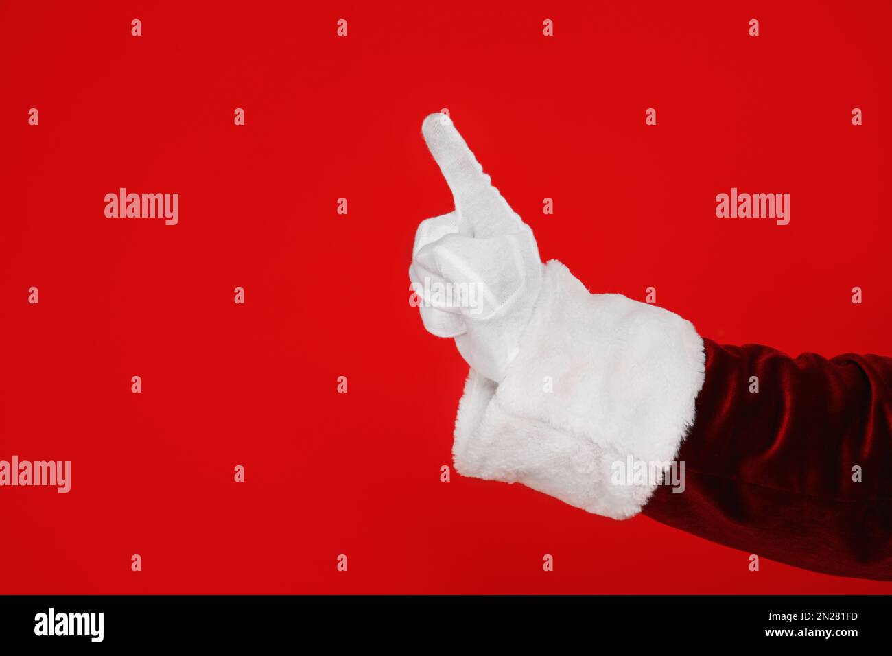 Santa Claus pointing at something on red background, closeup of hand ...